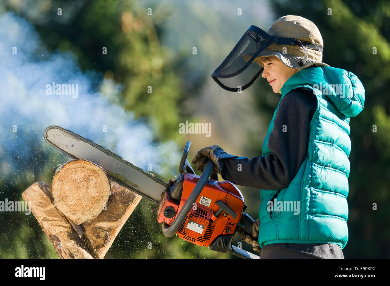 boy of ten with chainsaw cutting log Stock Photo - Alamy