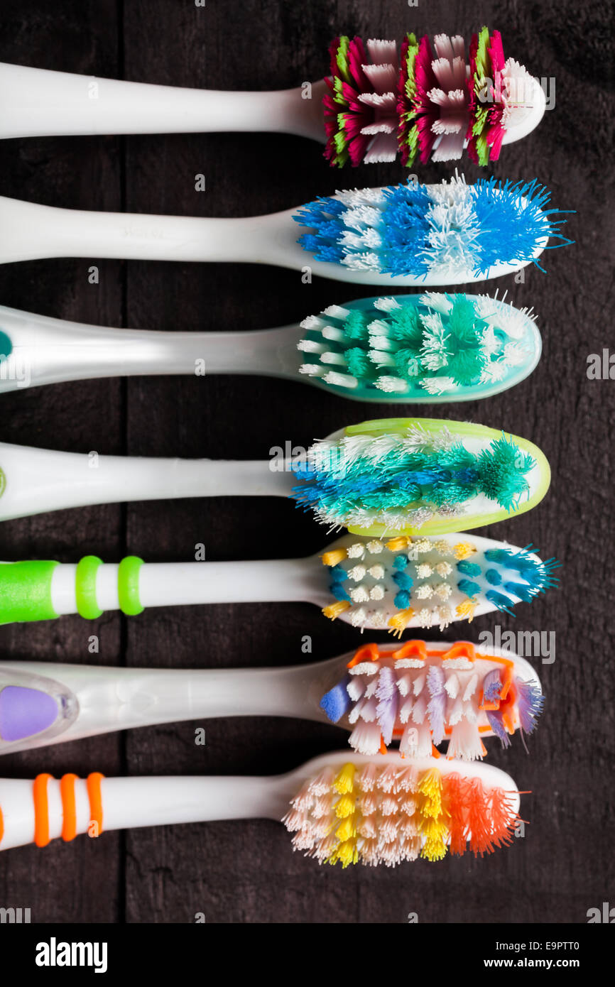 Colorful toothbrushes on black wooden background Stock Photo - Alamy