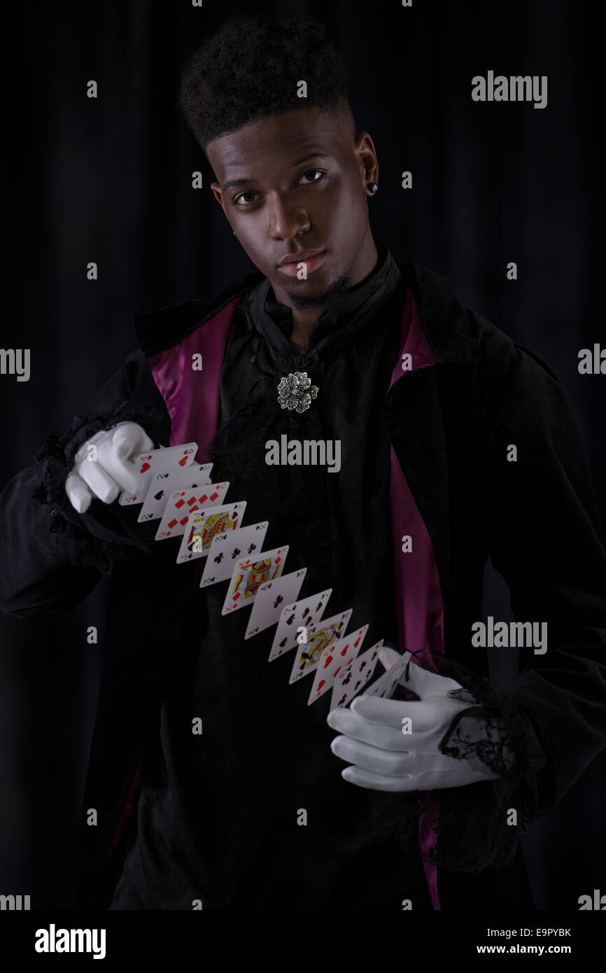 Magician performing on a stage with cards Stock Photo - Alamy