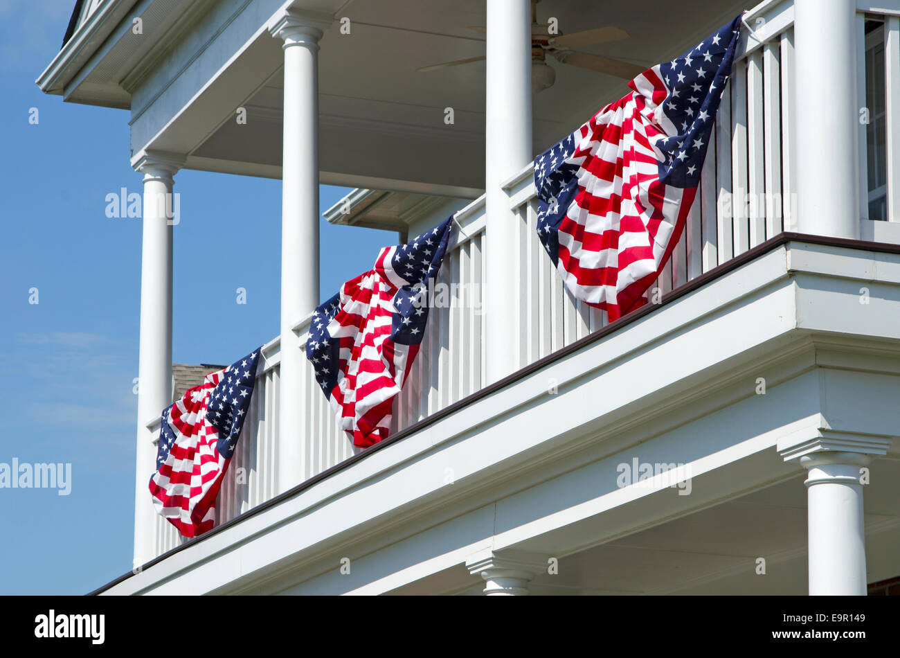 Buntings hang from a front porch of an upscale, brick home in ...