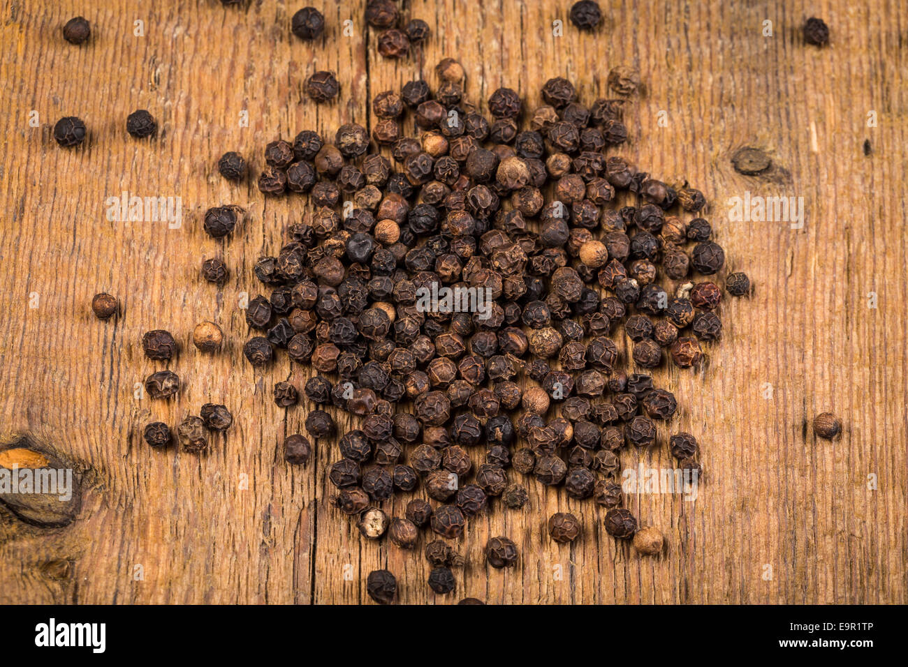 black pepper on a wood background table Stock Photo - Alamy