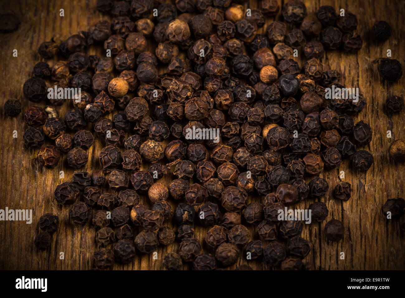 black pepper on a wood background table Stock Photo - Alamy