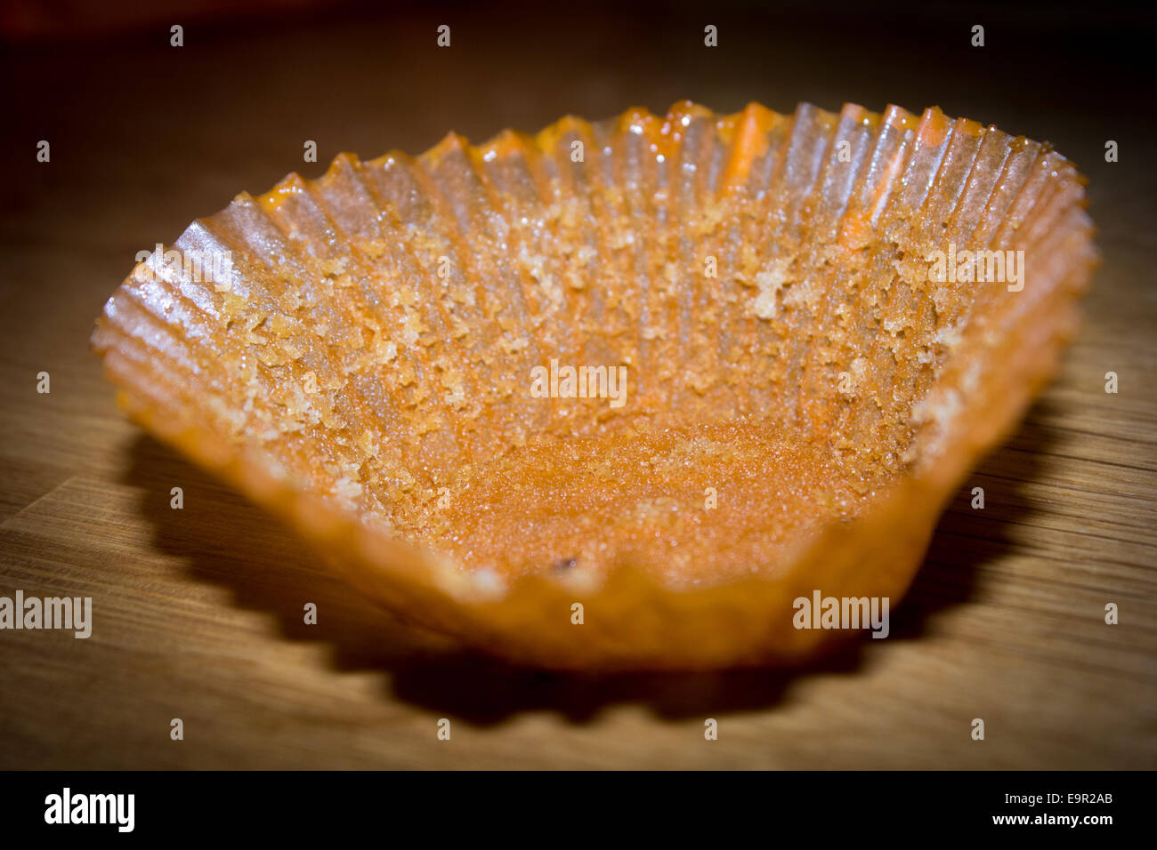 Empty cupcake casing on a wooden table Stock Photo - Alamy