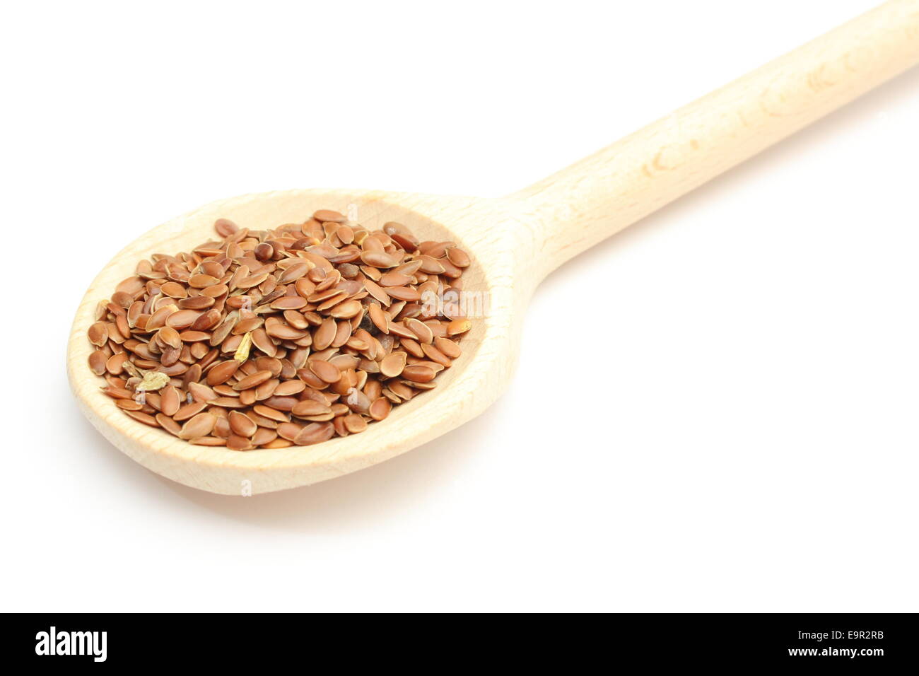 Heap of brown linseed on wooden spoon. Isolated on white background Stock Photo - Alamy