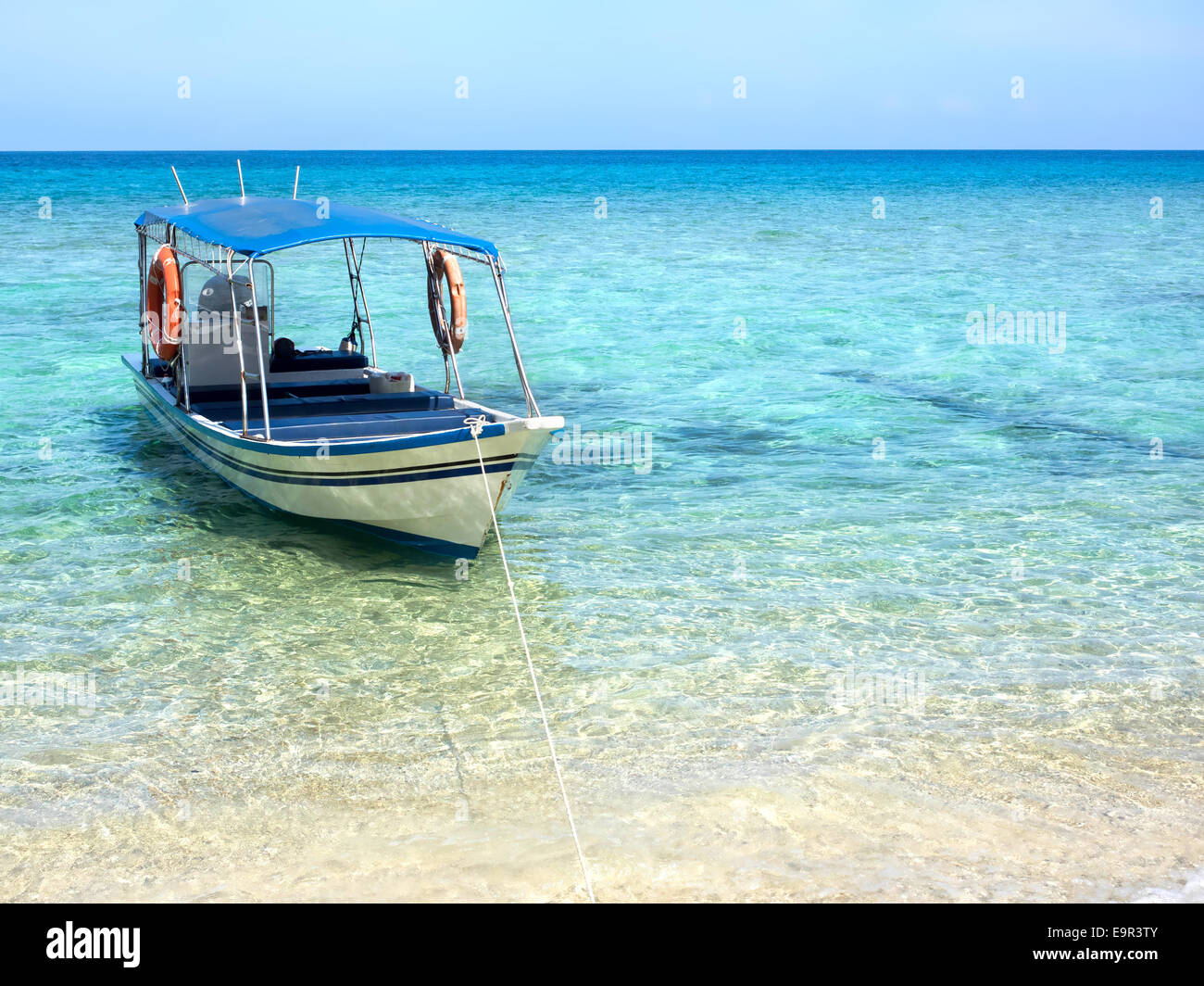 Boat floating on the turquoise colored waters of Perhentian Kecil ...