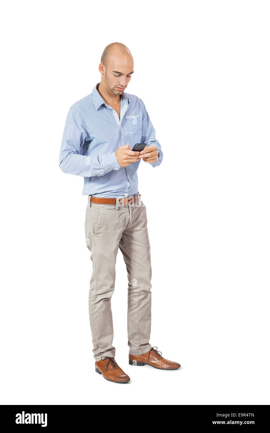 Handsome young man with a beard standing reading a text message on his ...