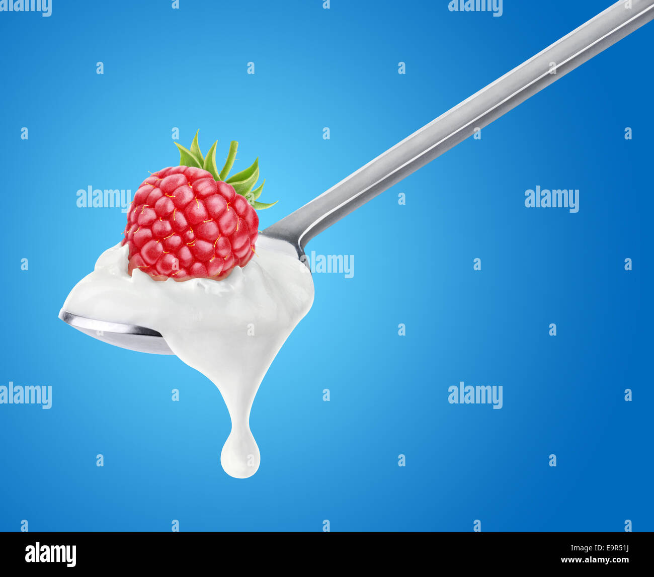 Spoon of raspberry yogurt on blue background Stock Photo - Alamy