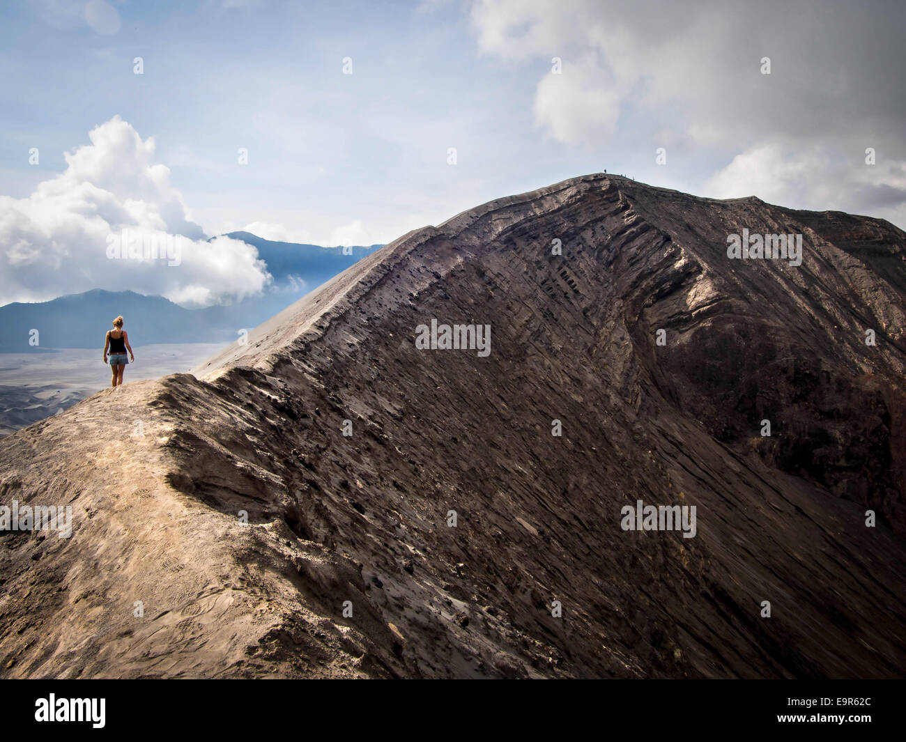 Hiker walking around the rim of Gunung Bromo volcano in East Java ...