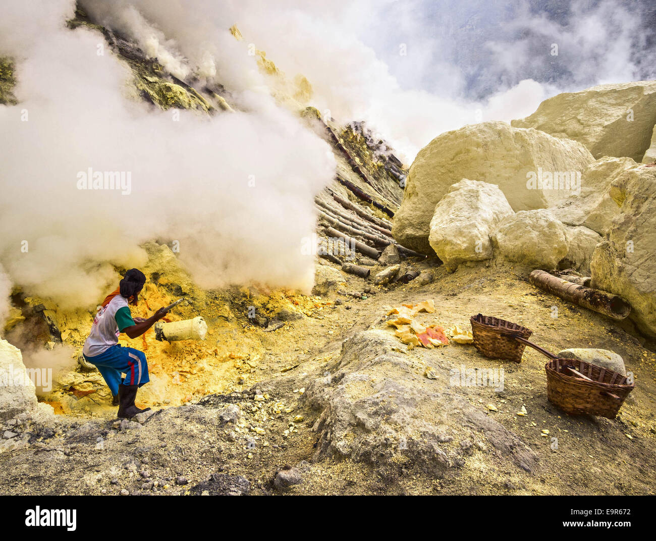 Sulfur miner collecting sulfur at Kawah Ijen volcano in East Java ...