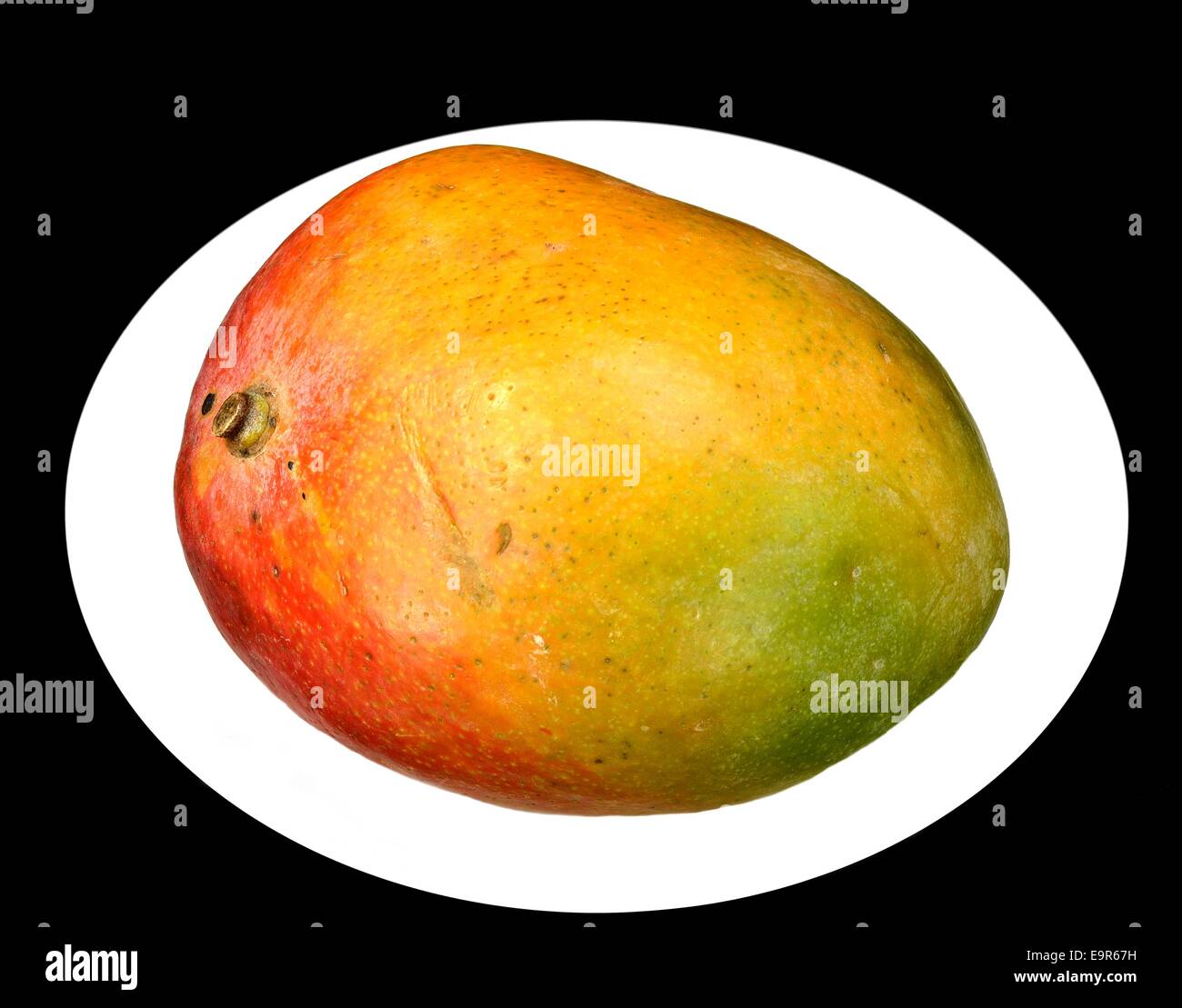 Mango on a plate on a black background Stock Photo - Alamy
