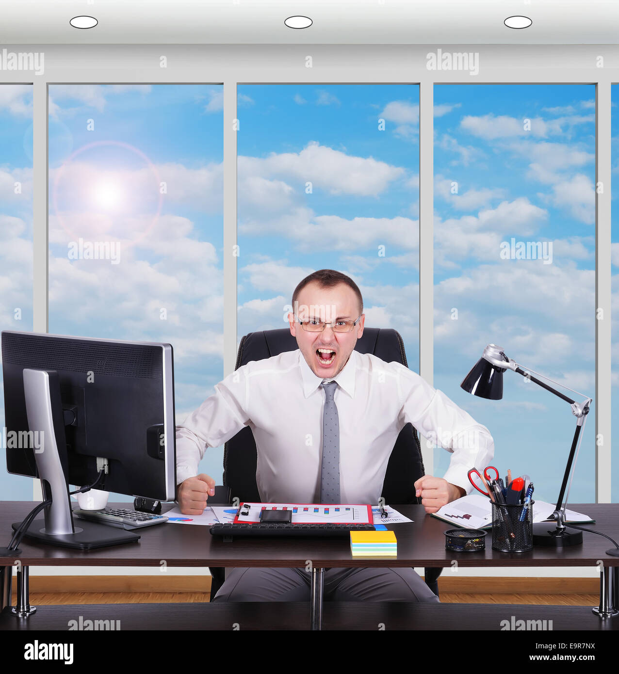 angry businessman sitting in office with big window Stock Photo - Alamy
