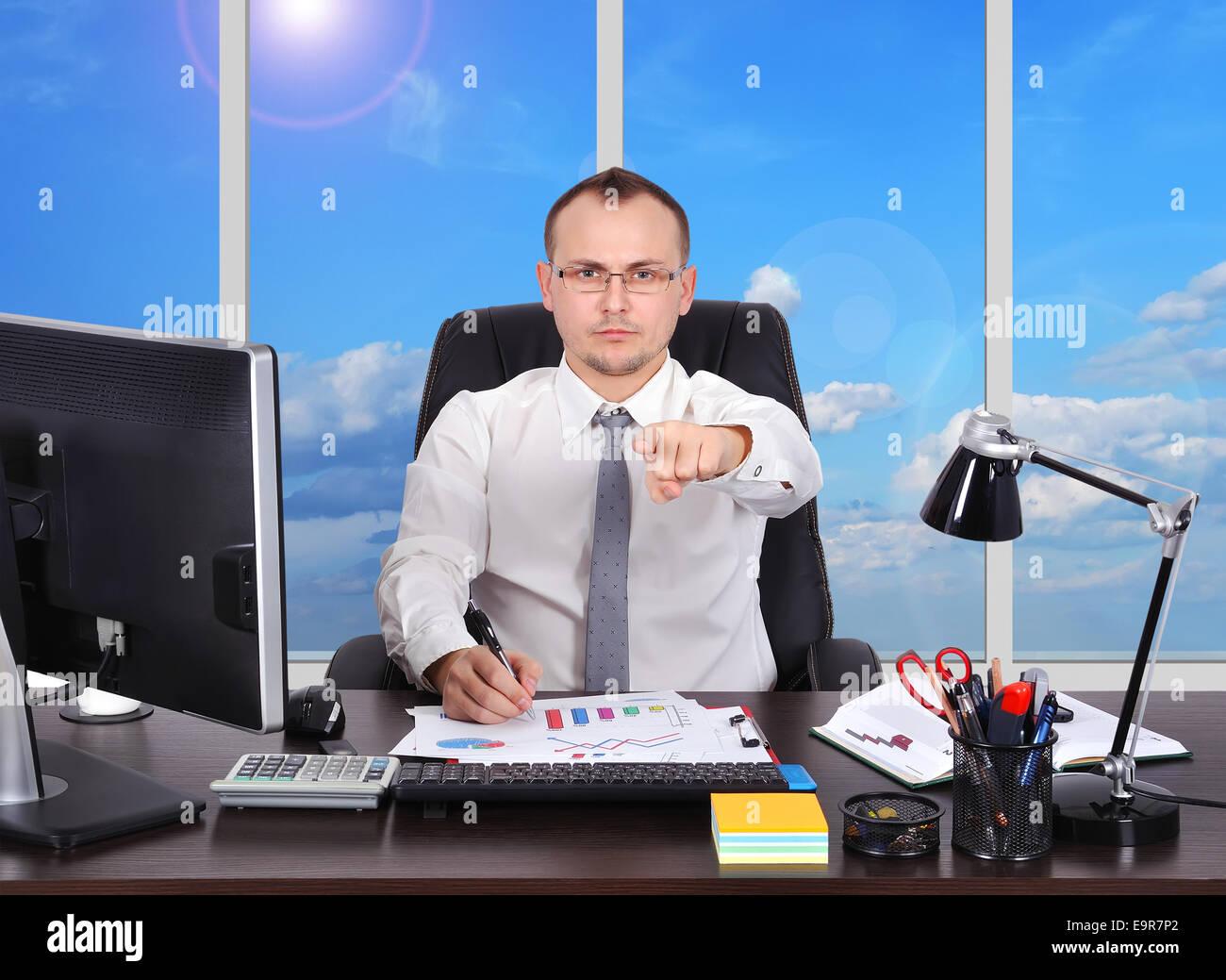 young businessman sitting in office and pointings finger Stock Photo ...