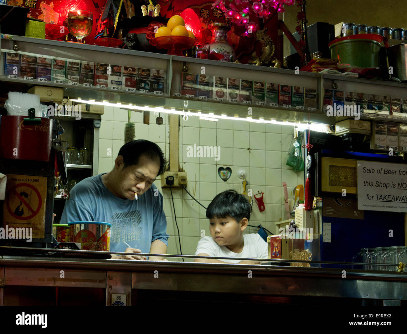 Bar owner and son at night time in Little India, Singapore Stock Photo ...