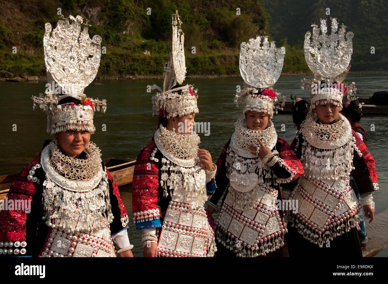 Four Miao girls with traditional wear and silver jewels in front of ...