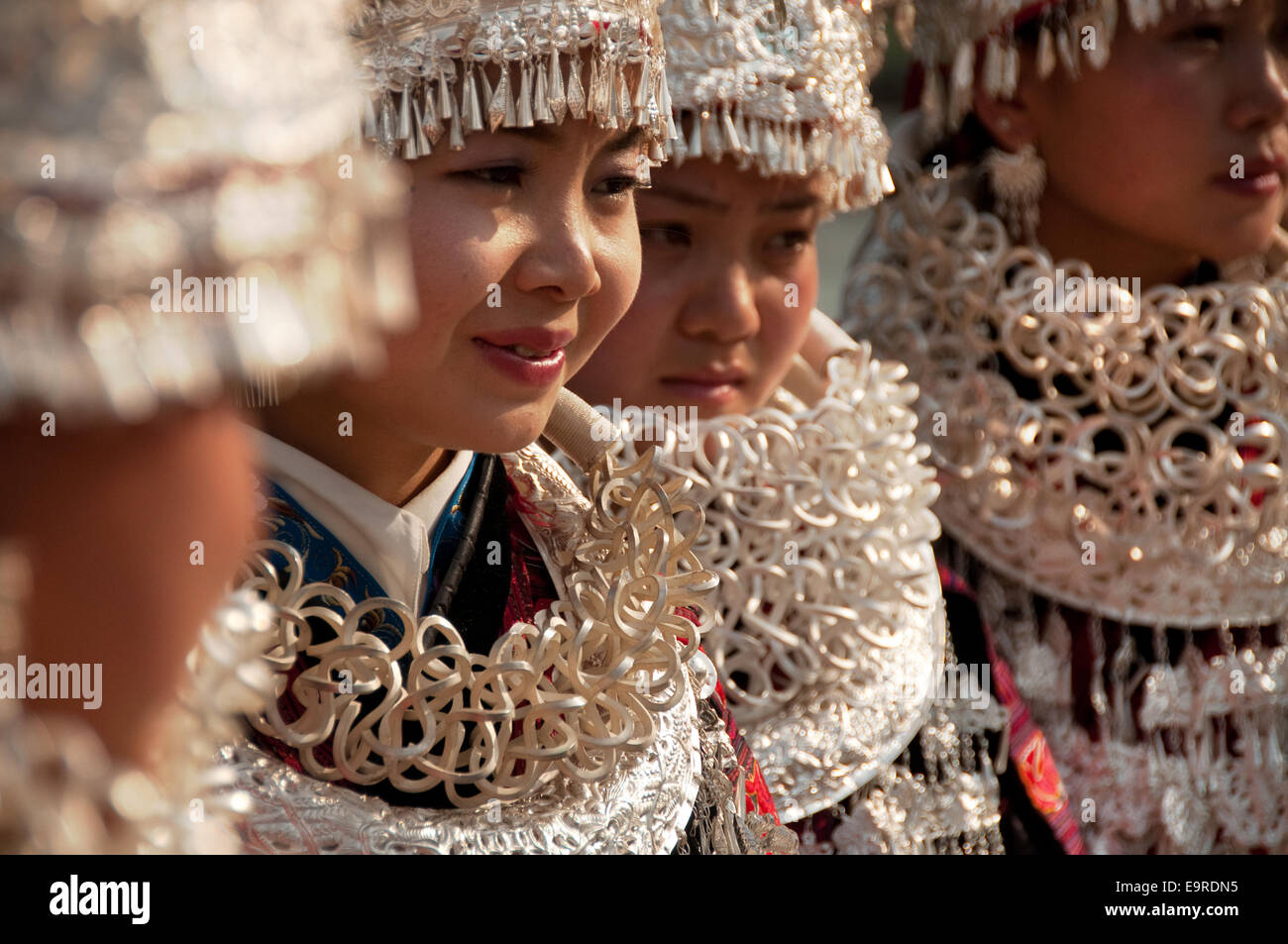 Four Miao girls with traditional wear and silver jewels in front of ...