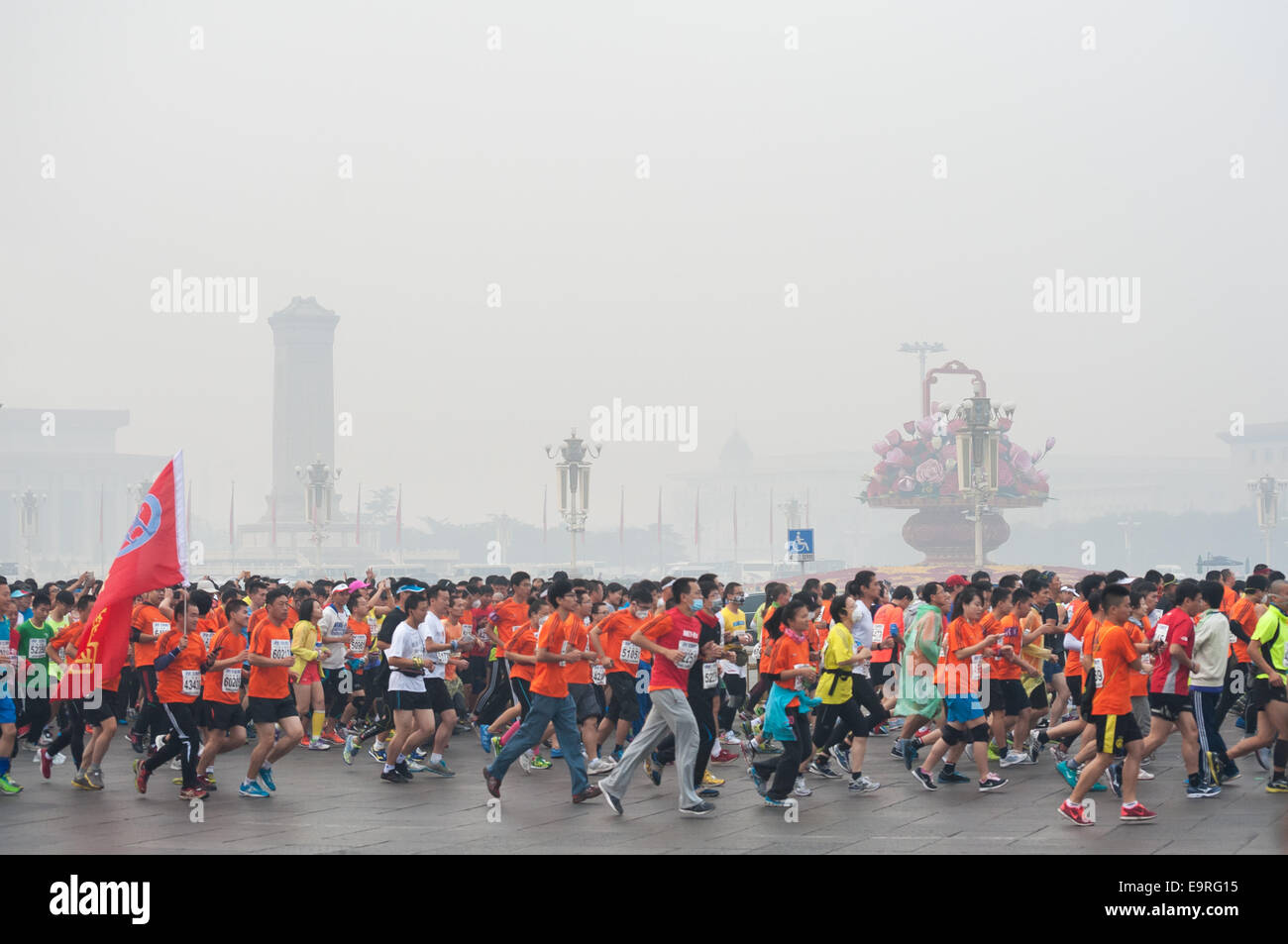 Runners run through the Tiananmen Square smog during the start of the ...