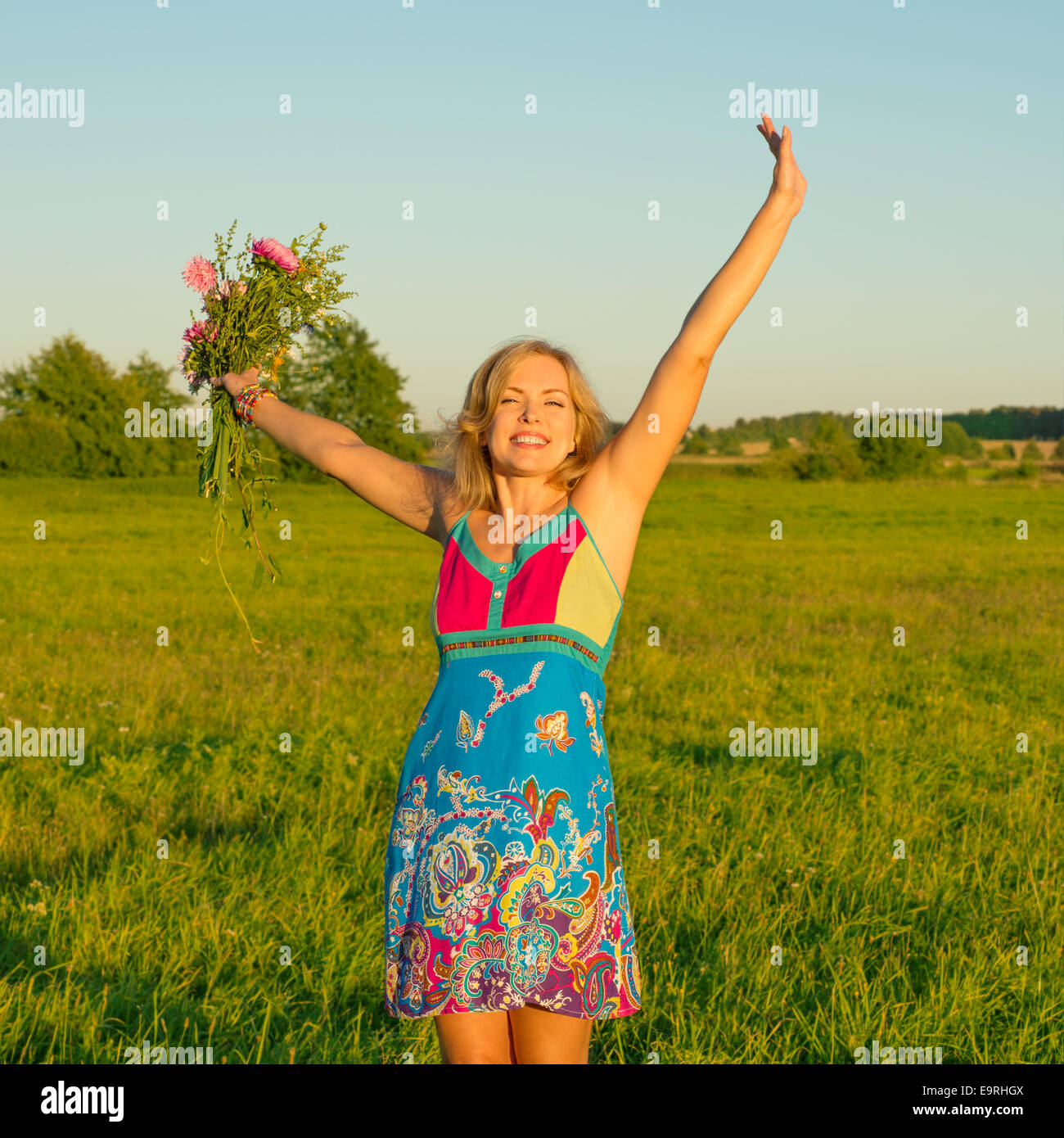 Happy woman on nature with flowers Stock Photo - Alamy