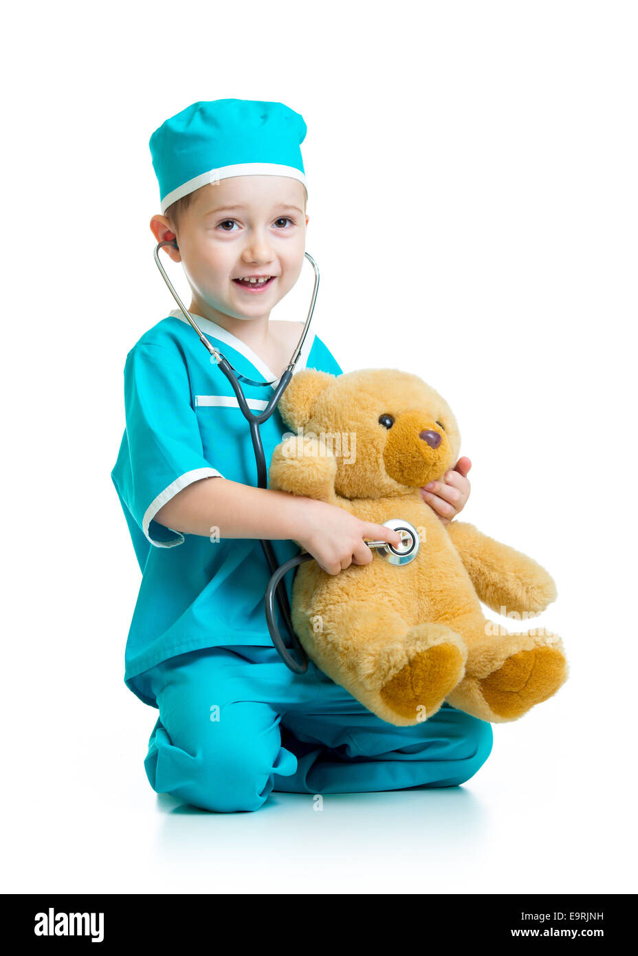 Adorable child with clothes of doctor examining bear toy Stock Photo ...