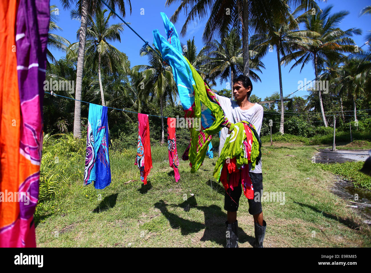 Master craftsman drying batik handicrafts, painted manually by hand ...