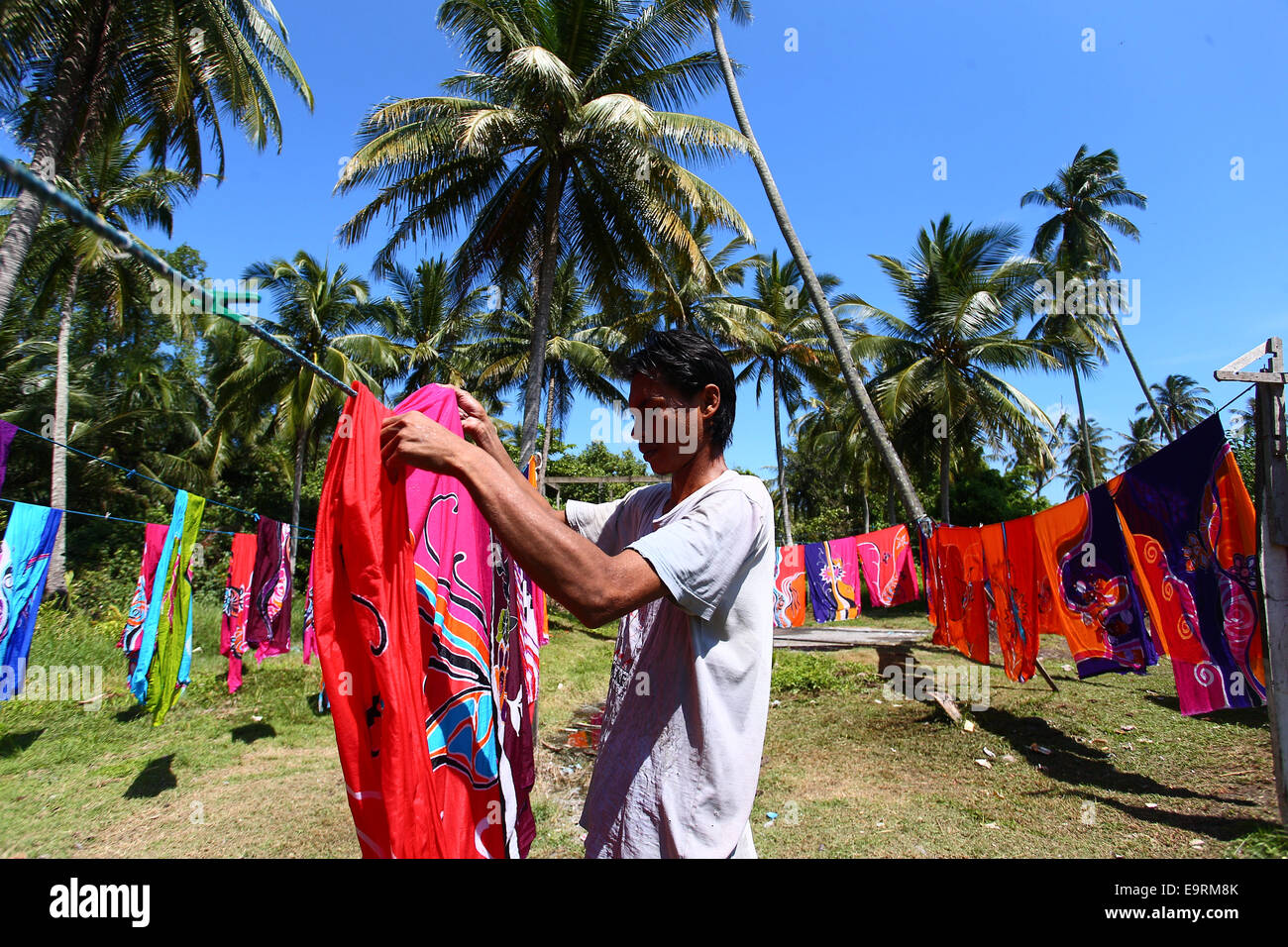 Master craftsman drying batik handicrafts, painted manually by hand ...