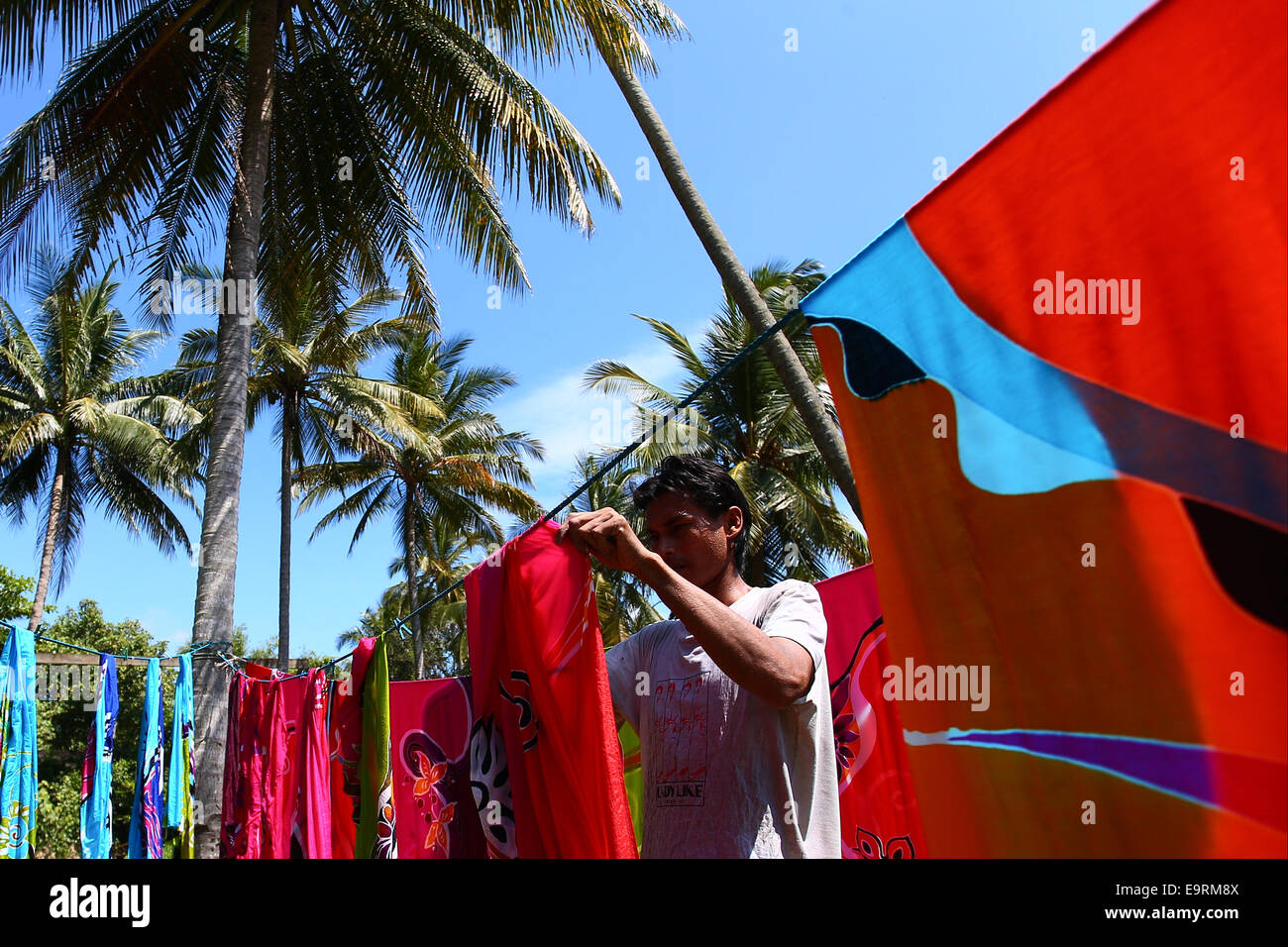 Master craftsman drying batik handicrafts, painted manually by hand ...