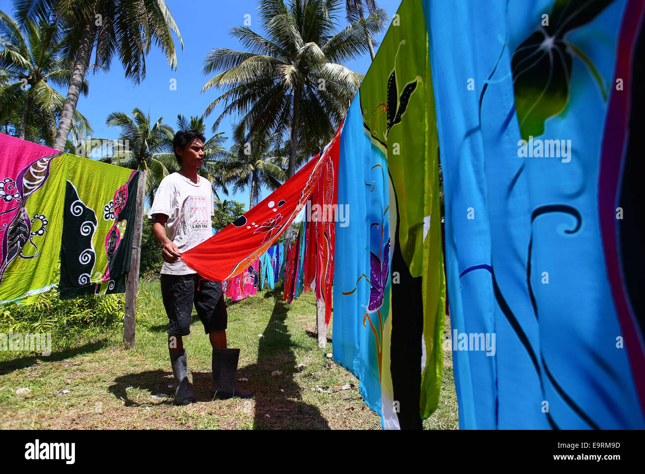 Master craftsman drying batik handicrafts, painted manually by hand ...