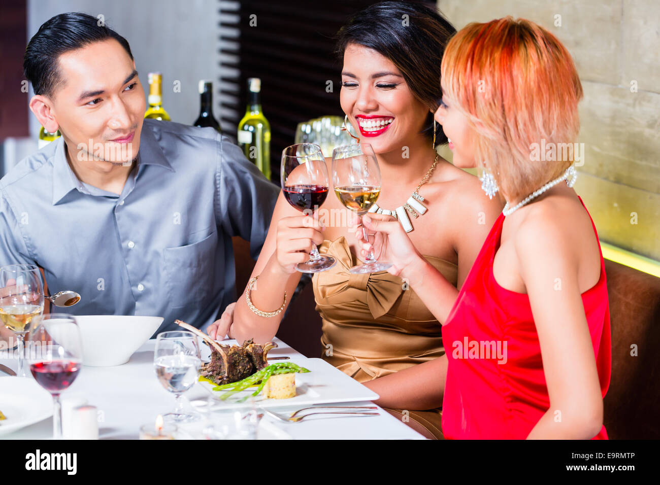 Asian friends, two couples, dining in fancy restaurant eating good food ...