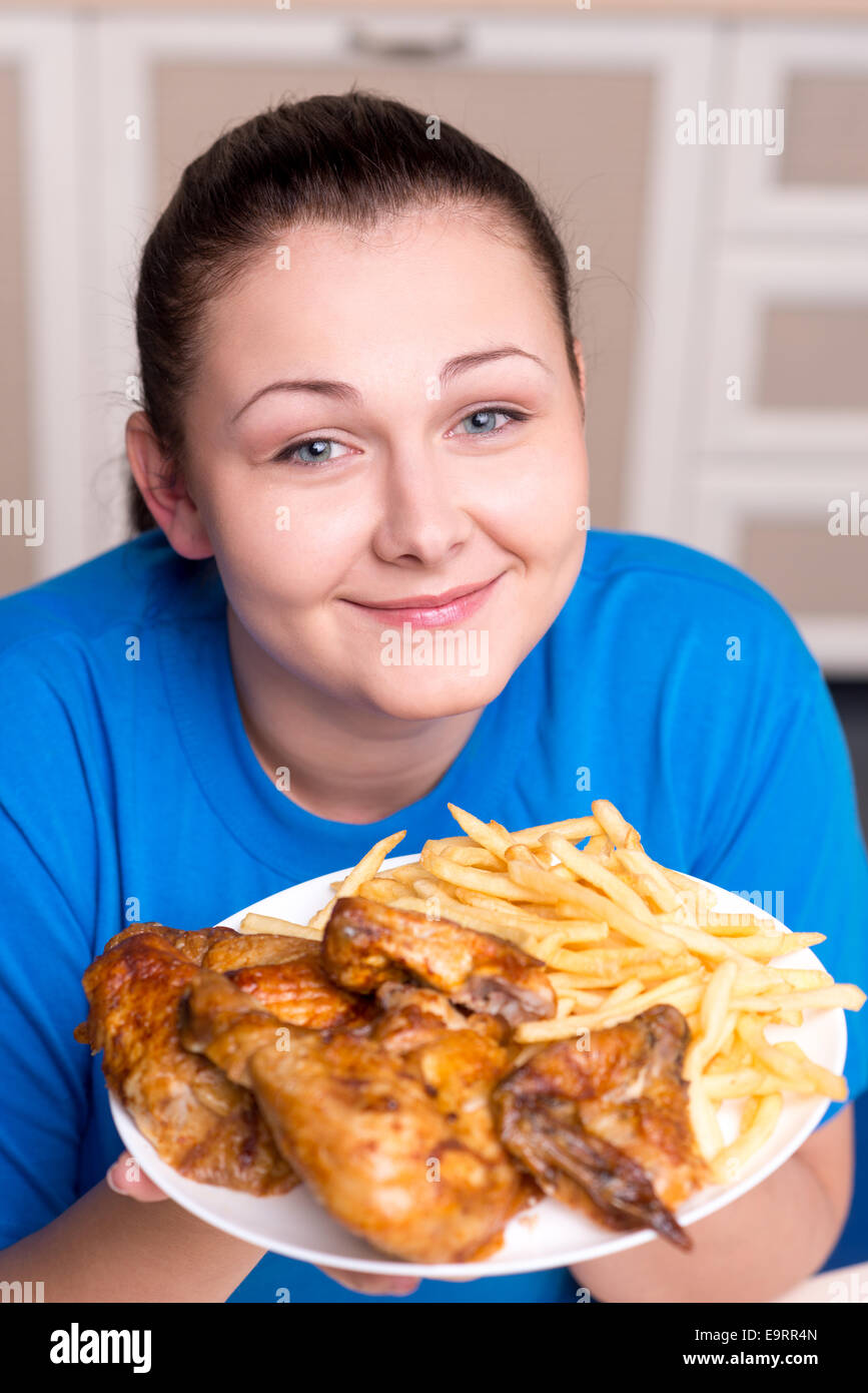 Overweight pretty woman desiring to eat big unhealthy plate with fried ...