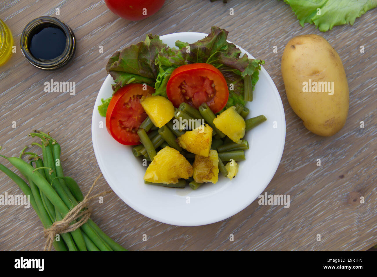 A plate of French string beans on the black wooden surface. Top view ...