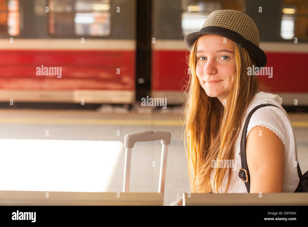 Portrait of young cute girl traveler waiting for his train at the ...