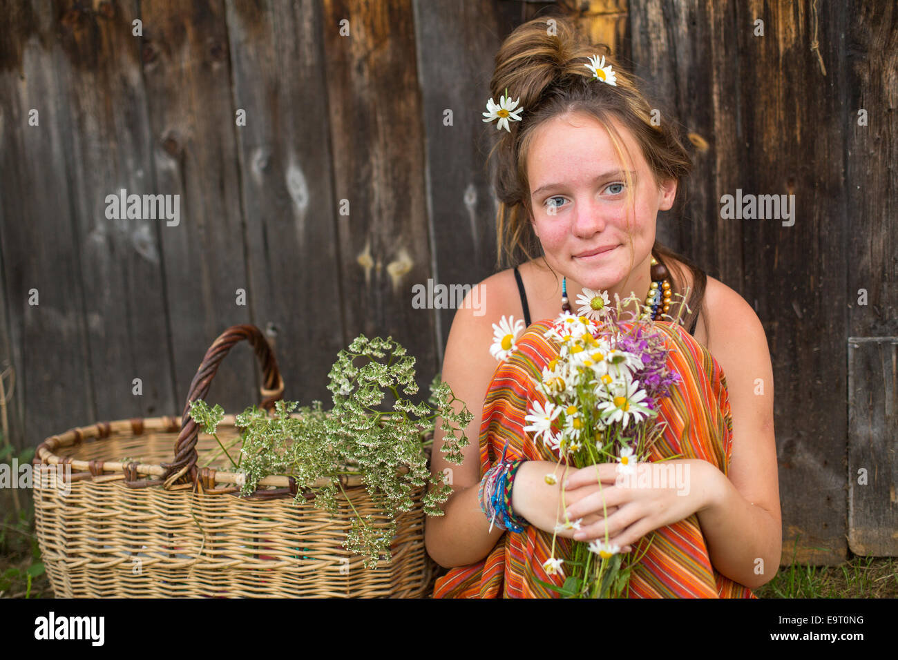 Pretty rustic girl sitting outdoors with a basket Stock Photo - Alamy