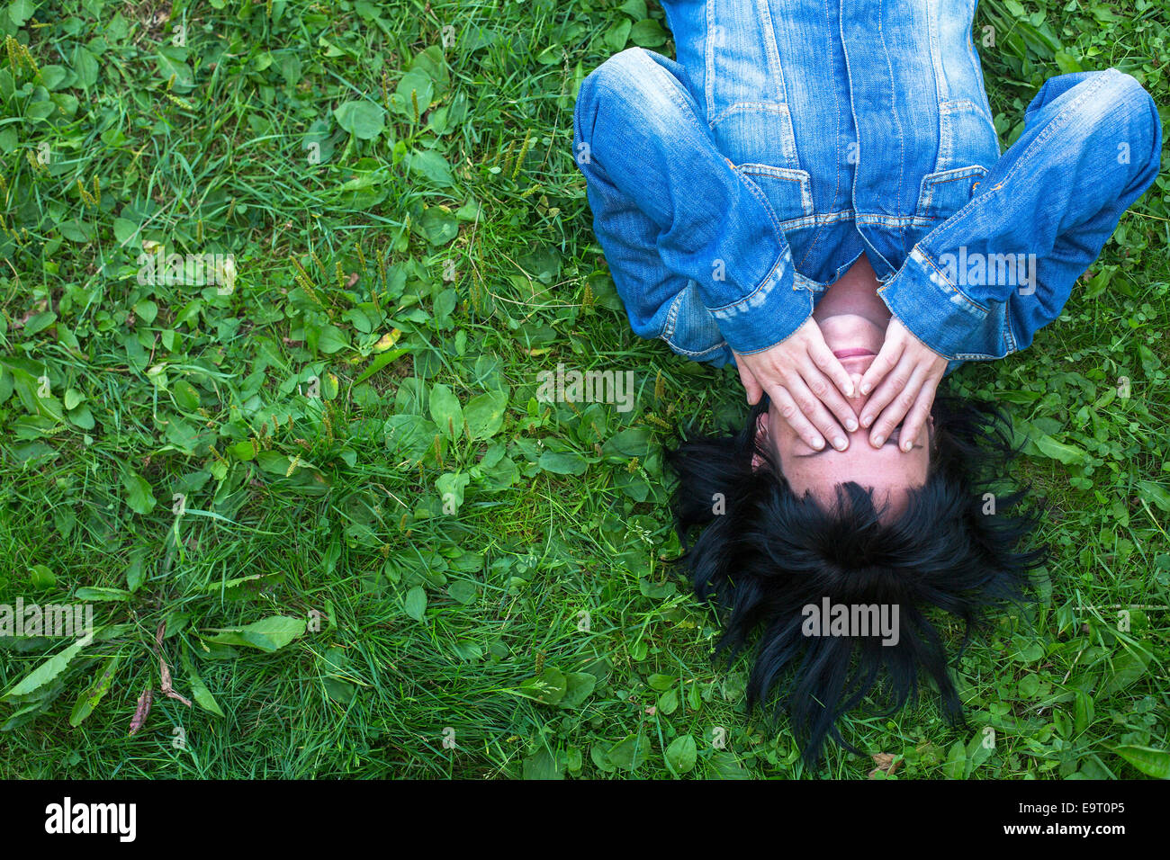 Girl in a denim jacket lying on the grass (with space for text Stock ...