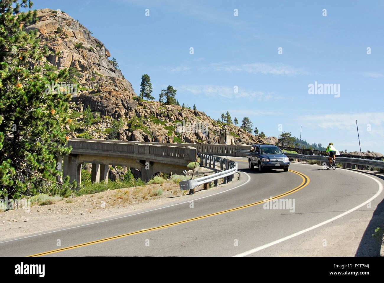 Car and bicyclist on Highway 40 and bridge over Donner Pass in Sierra ...