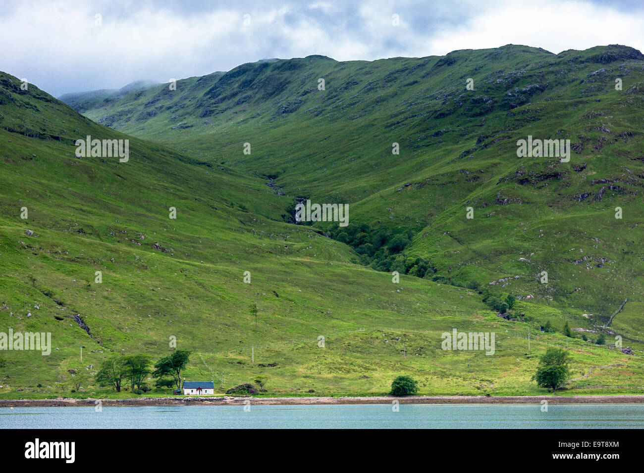 Traditional Scottish small white croft cottage on the shores of Loch a ...