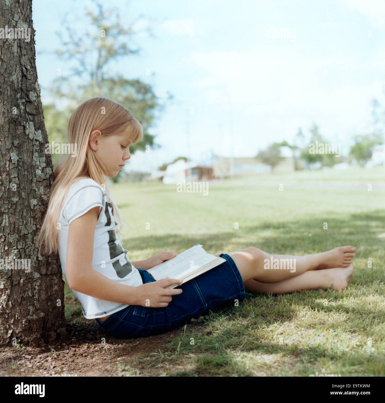 Girl Reading Book by Tree Stock Photo - Alamy