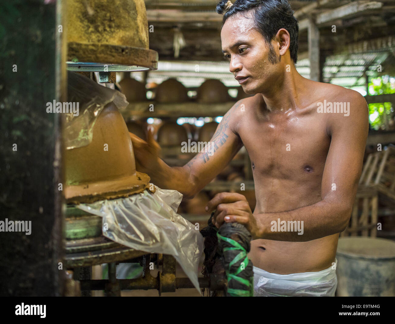 Twante, Yangon Division, Myanmar. 2nd Nov, 2014. A worker pulls a clay ...