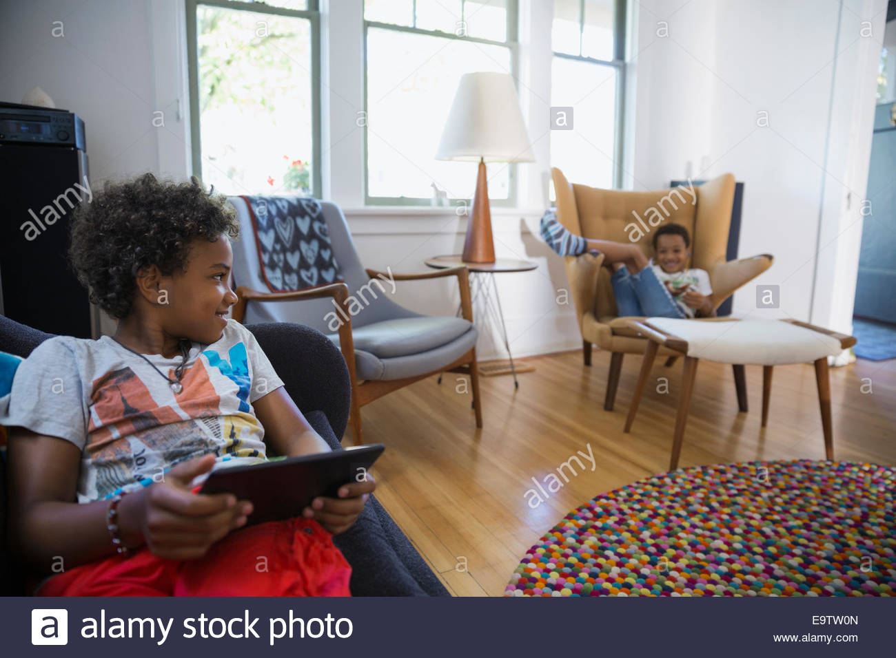 Brothers using technology in living room Stock Photo - Alamy