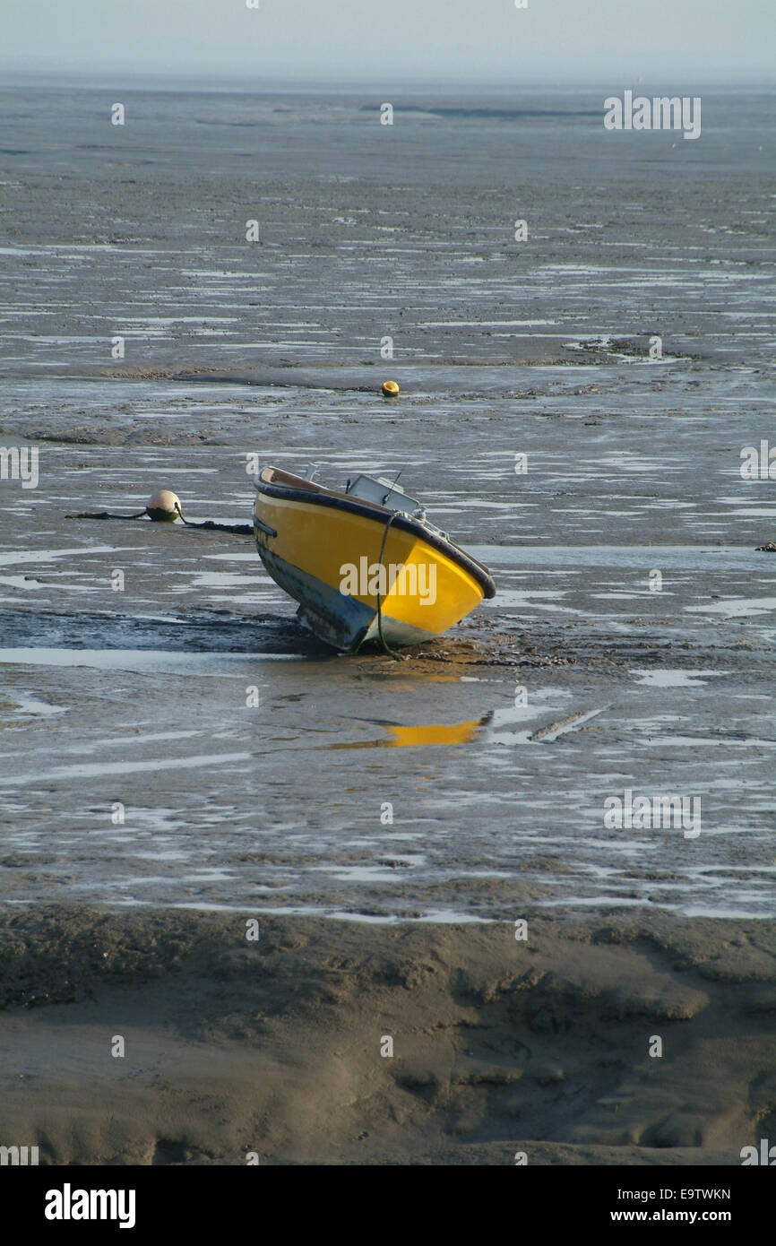 Yellow Dingy grounded on mud Stock Photo - Alamy