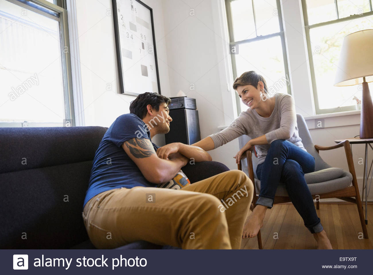 Couple talking in living room Stock Photo - Alamy