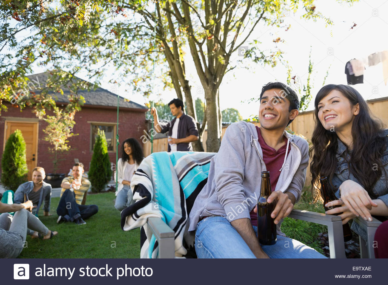Friends hanging out at backyard barbecue Stock Photo - Alamy
