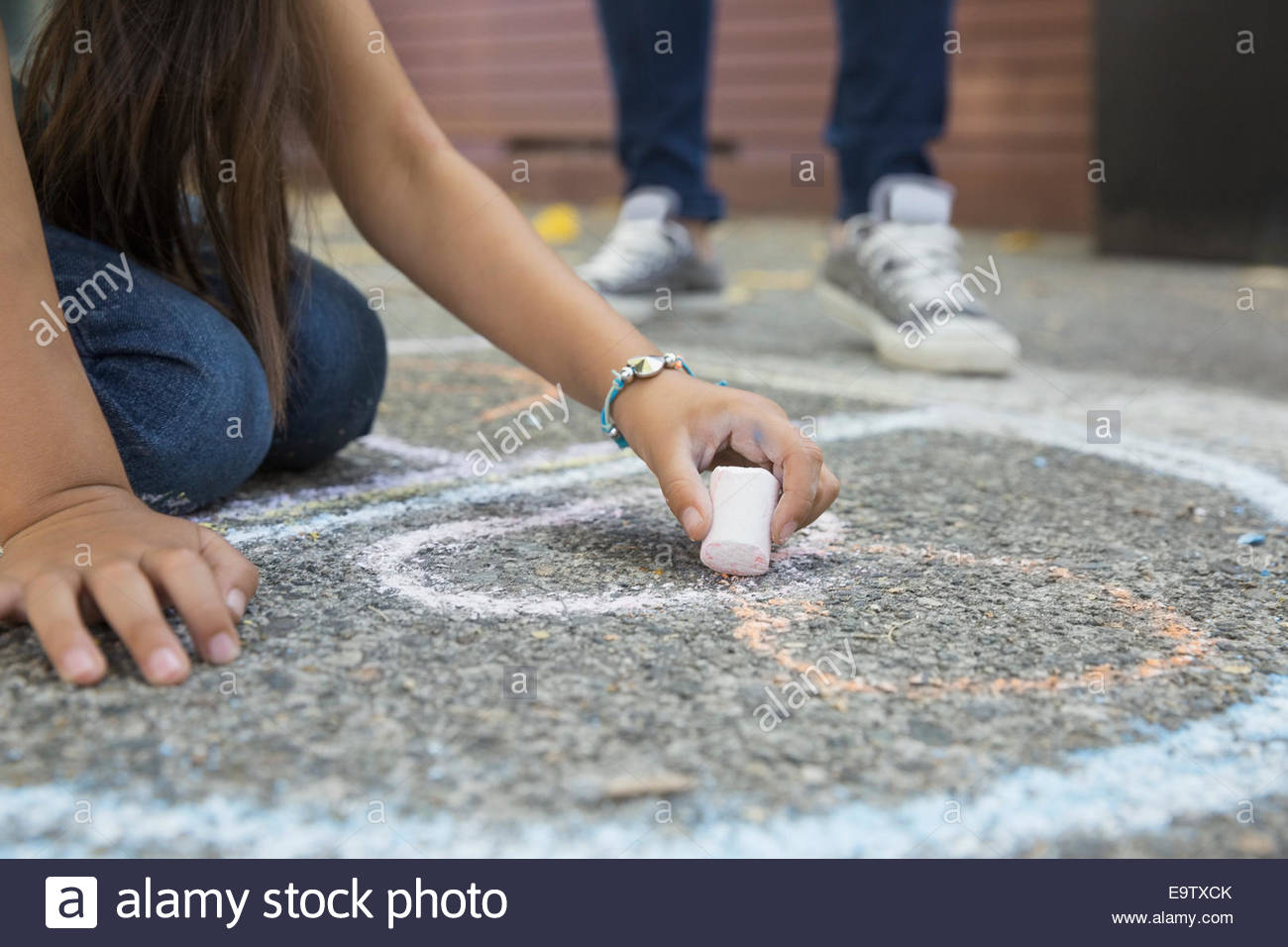 Girl drawing hopscotch number 8 with sidewalk chalk Stock Photo - Alamy