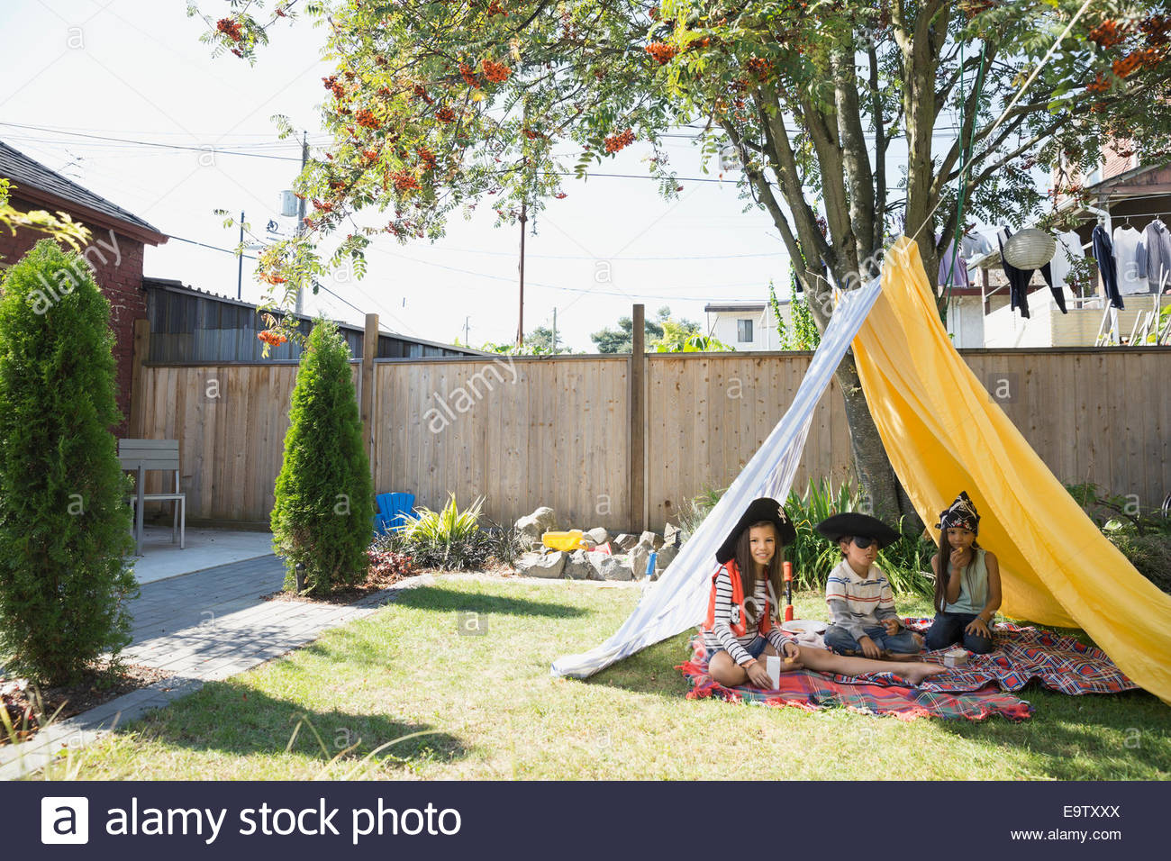 Children playing pirates in backyard fort Stock Photo - Alamy