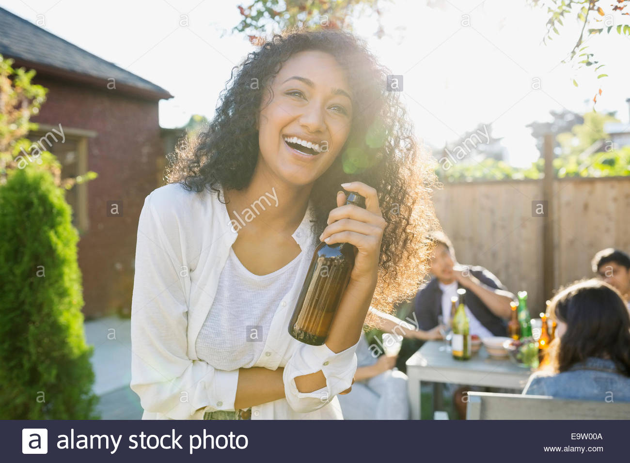Laughing woman drinking beer at backyard barbecue Stock Photo - Alamy