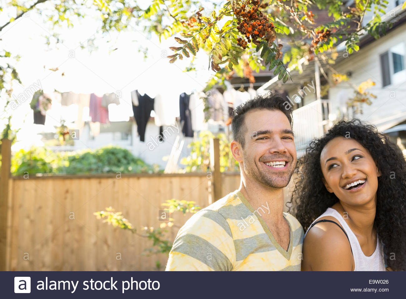 Portrait of laughing couple in sunny backyard Stock Photo - Alamy