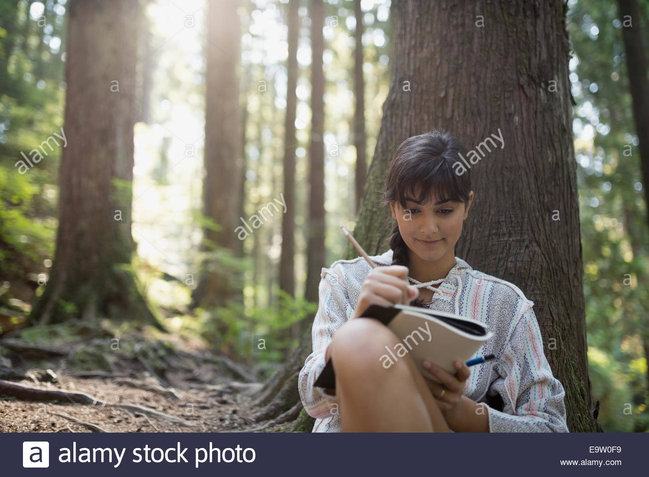 Woman sitting against tree trunk hi-res stock photography and images ...