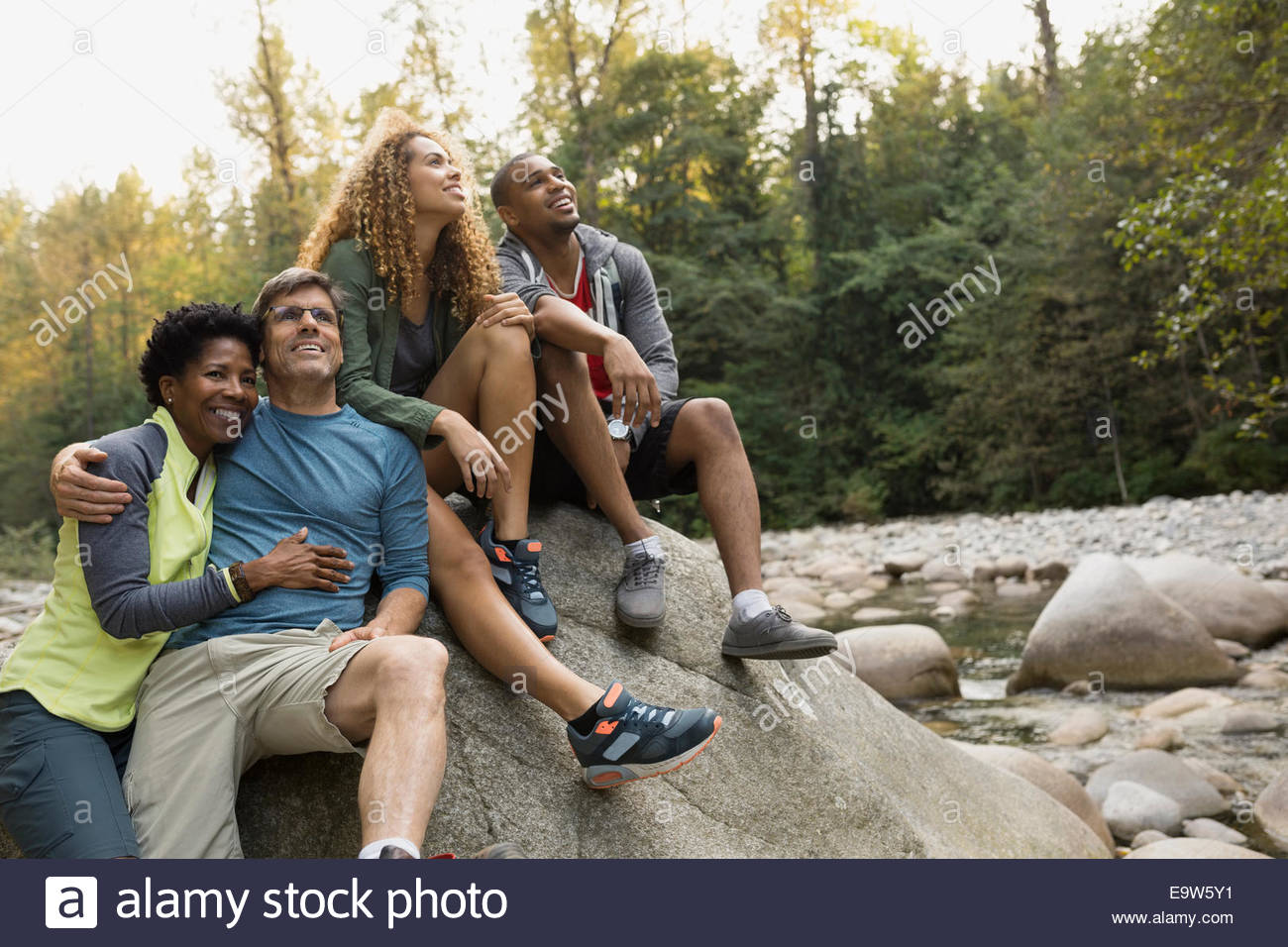 Friends on large rock in woods Stock Photo - Alamy