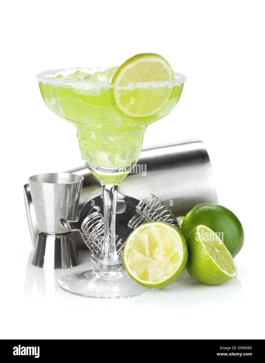 Classic margarita cocktail with salty rim, limes and drink utensils ...