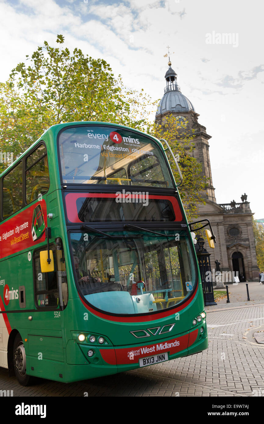 A Green bus traveling down Colmore Row past Birmingham Cathedral in the ...