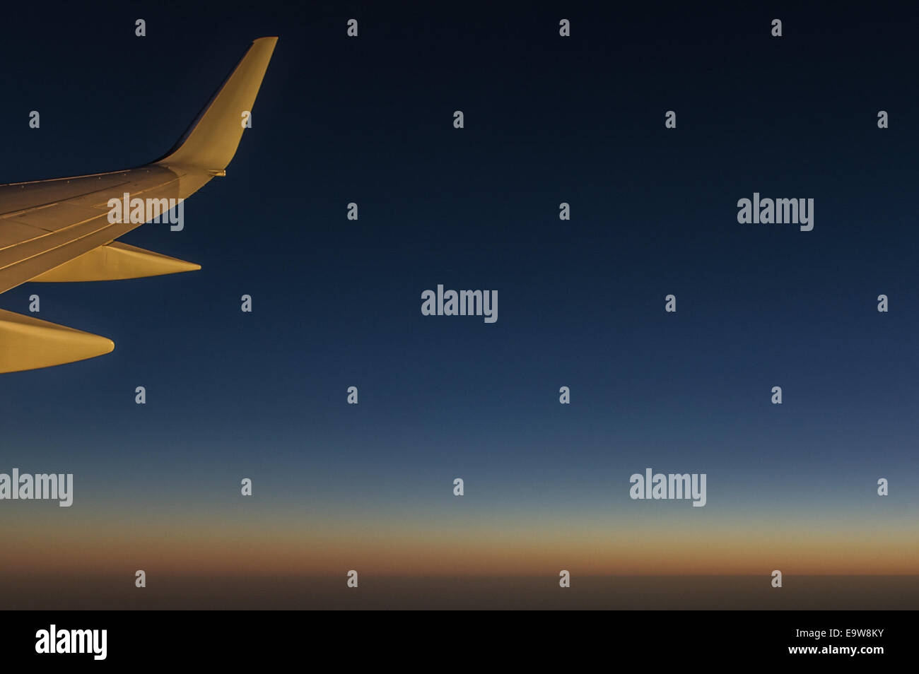 The setting sun highlights the wing of the Air Force jet carrying U.S ...