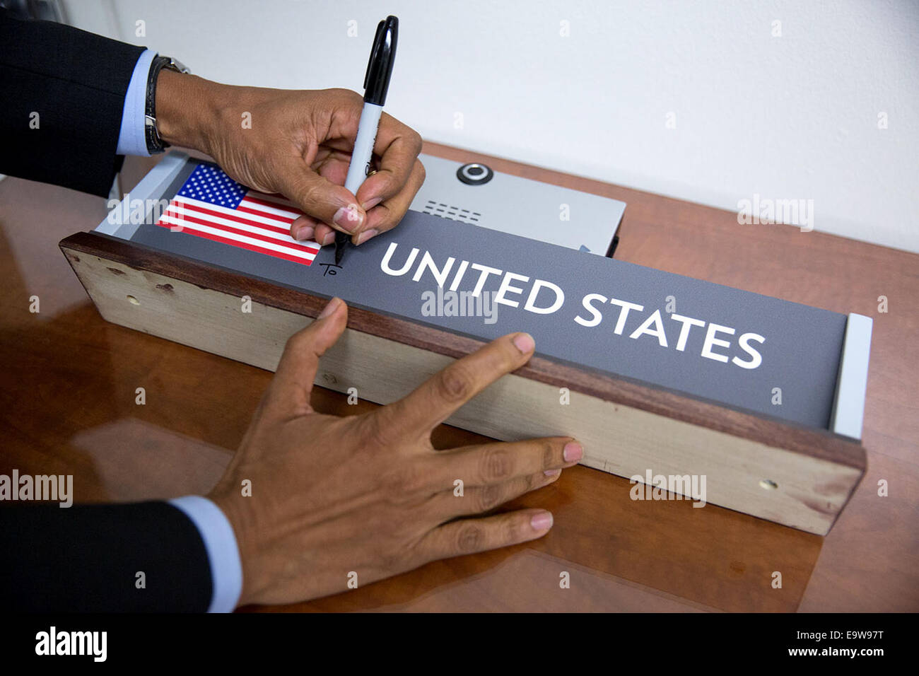 President Barack Obama signs a United States name plate at the ...